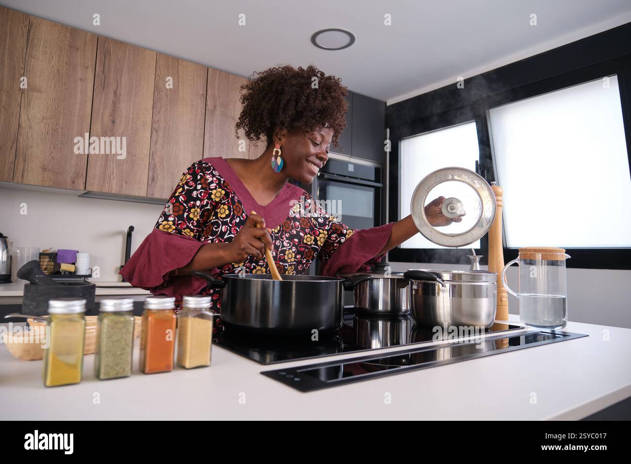 Woman cooking african okro soup with spinach in modern kitchen Stock ...