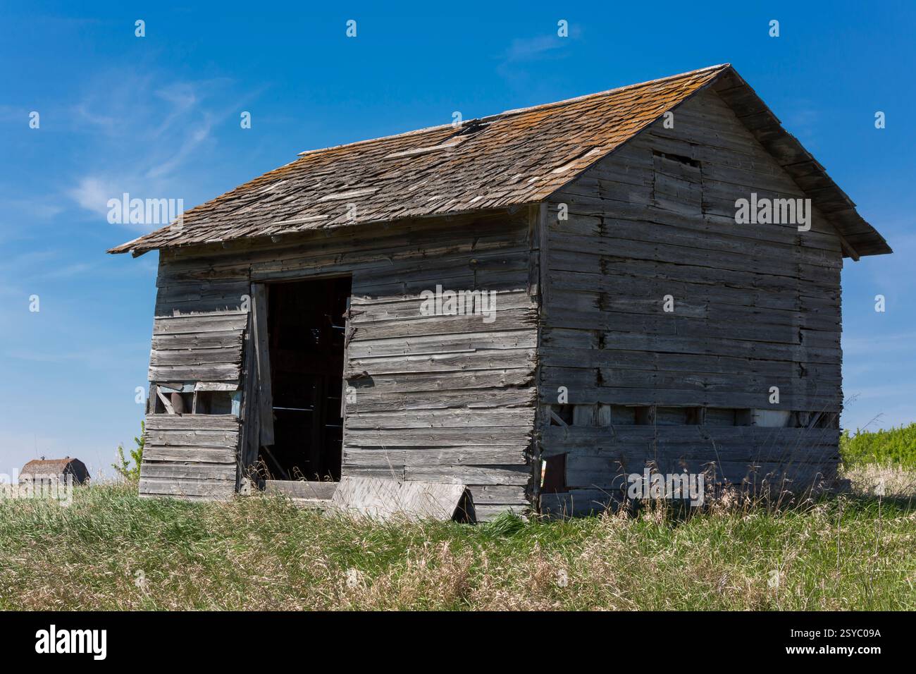 Small, old, wooden building with a slanted roof. The roof is covered in ...