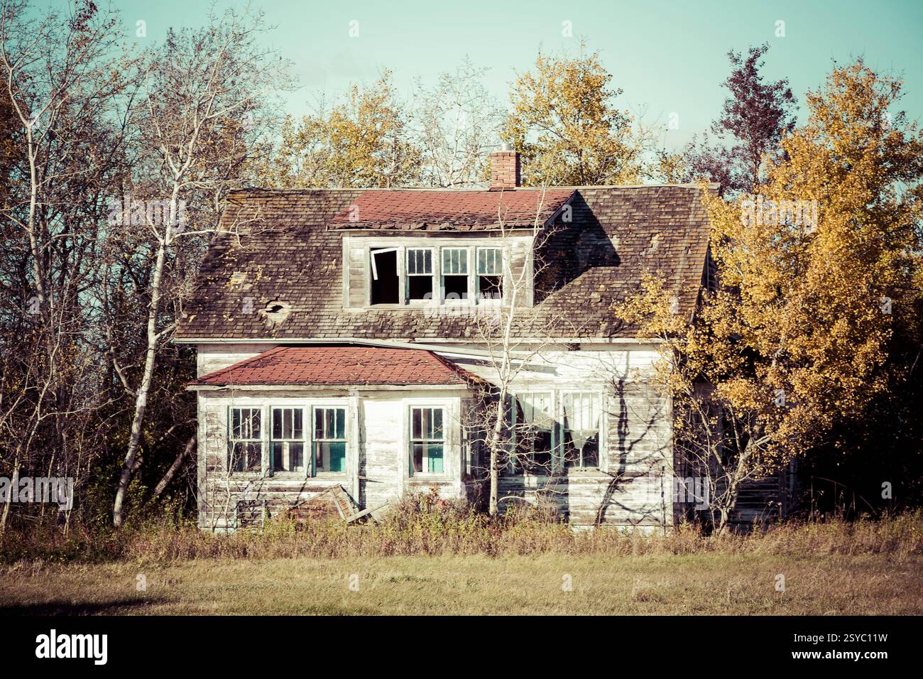 House with a red roof and white siding. The roof is missing shingles ...