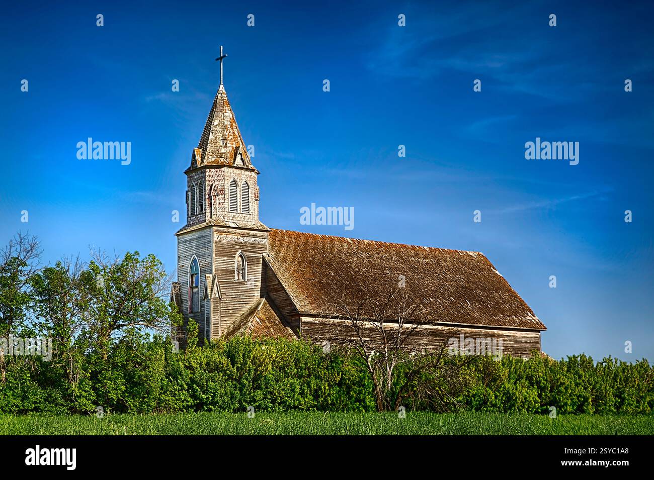 Small church with a steeple and a cross on top. The church is ...