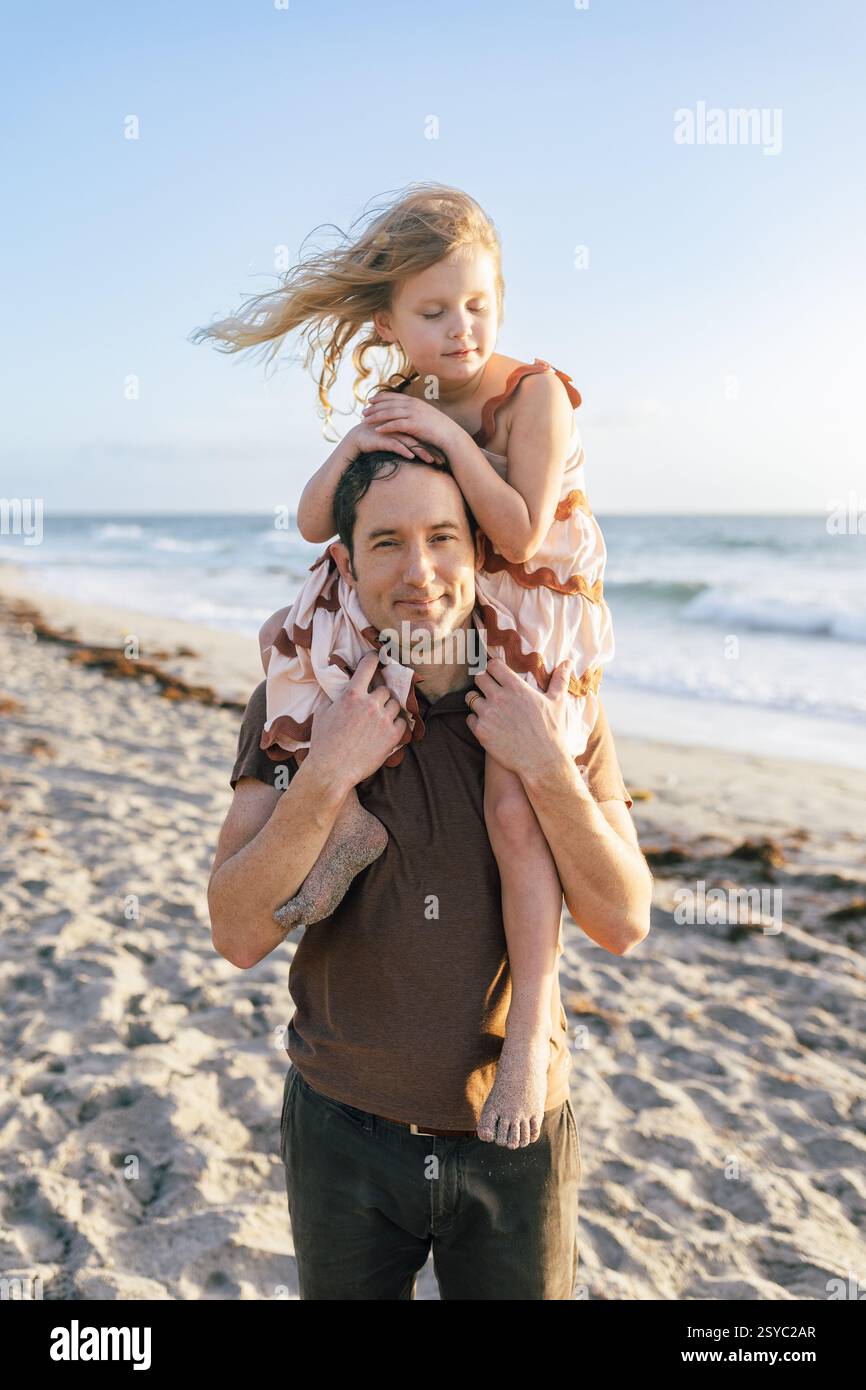 Father giving Daughter shoulder ride on the beach Stock Photo - Alamy