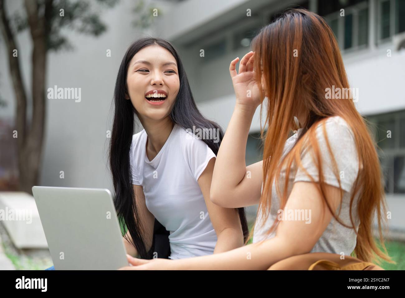 Two university students laughing and sharing ideas, promoting ...