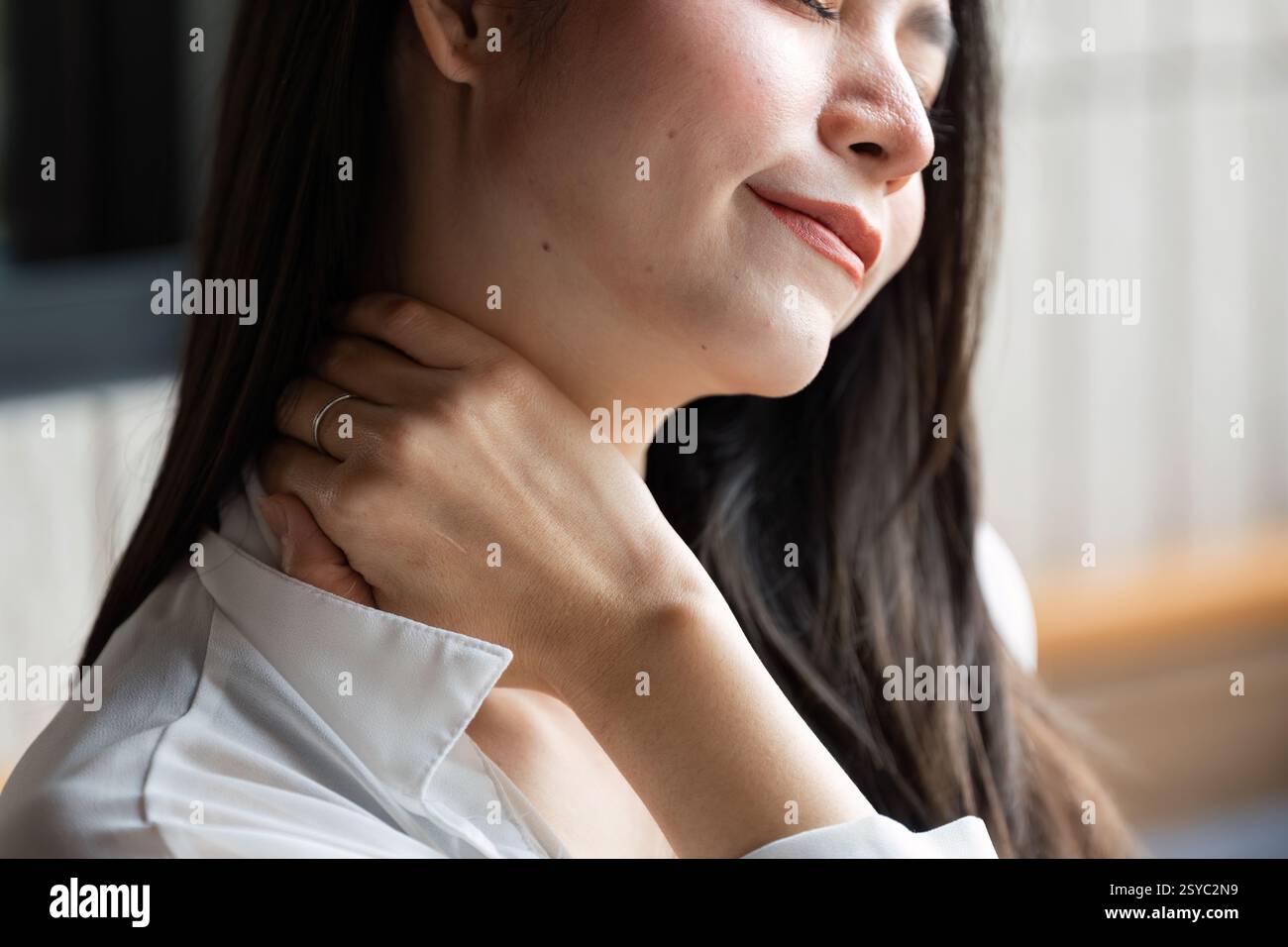 Woman experiencing neck discomfort while working, highlighting the ...