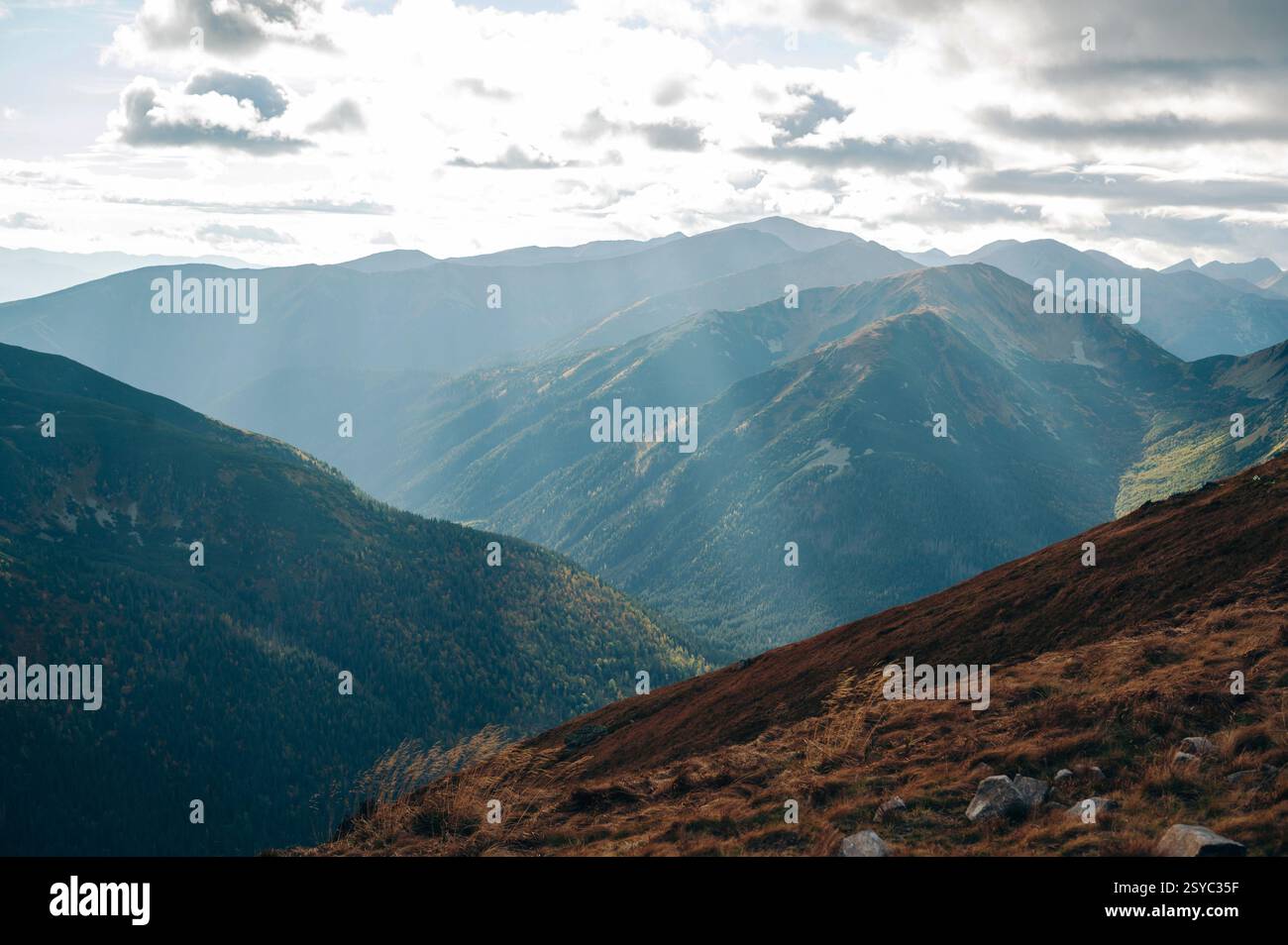 Sunlit Mountain Range with Clouds and Valleys Stock Photo - Alamy