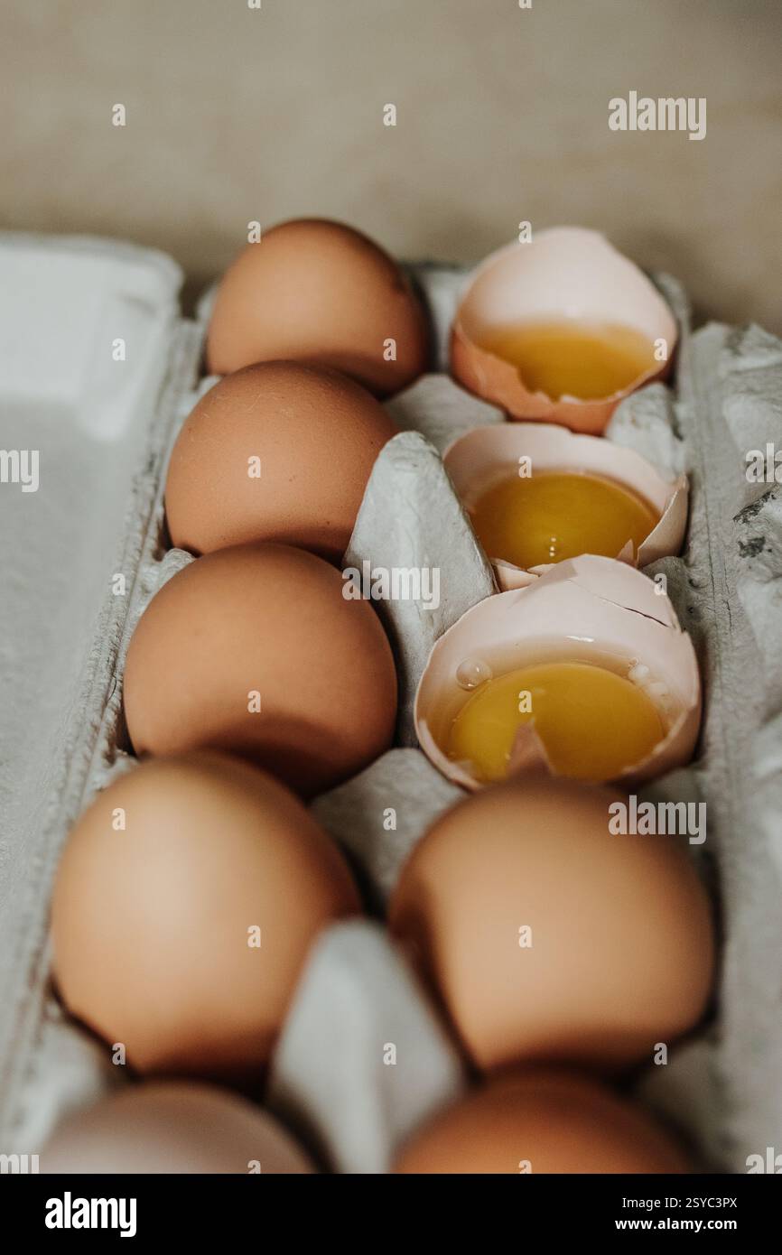Overhead view of three cracked open eggs sitting in full carton Stock ...