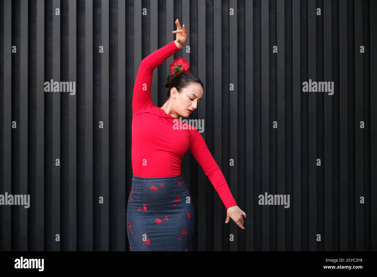 Flamenco dancer performing with red clothes against black background ...