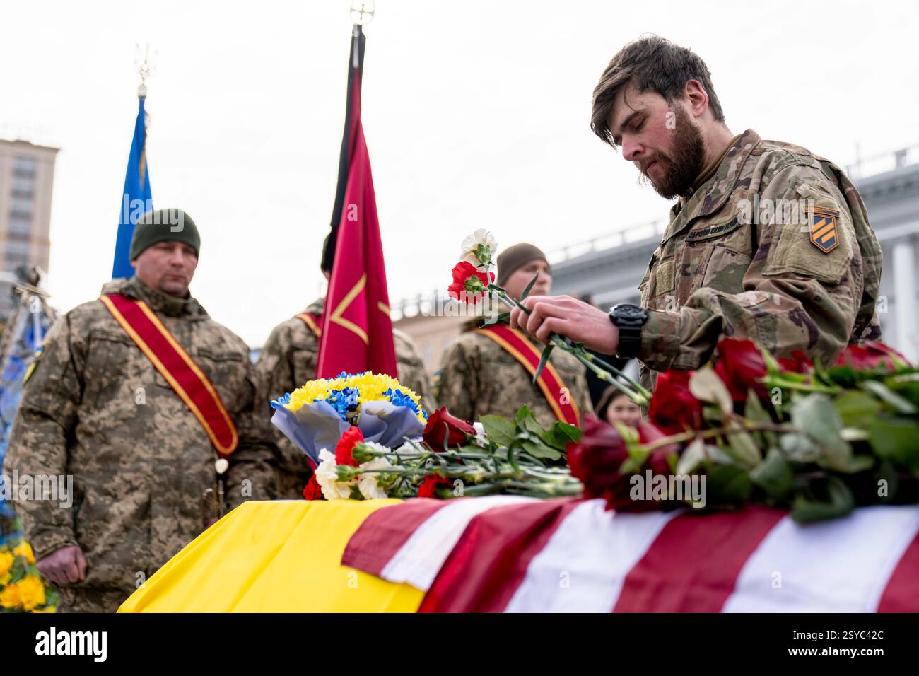 Friends and fellow soldiers lay flowers on coffin at Memorial service ...