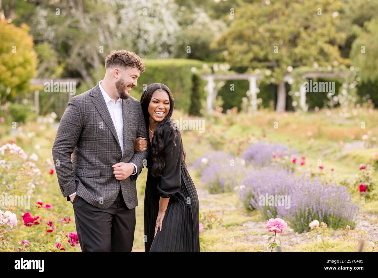 Couple sharing laughter in a beautiful garden setting Stock Photo - Alamy
