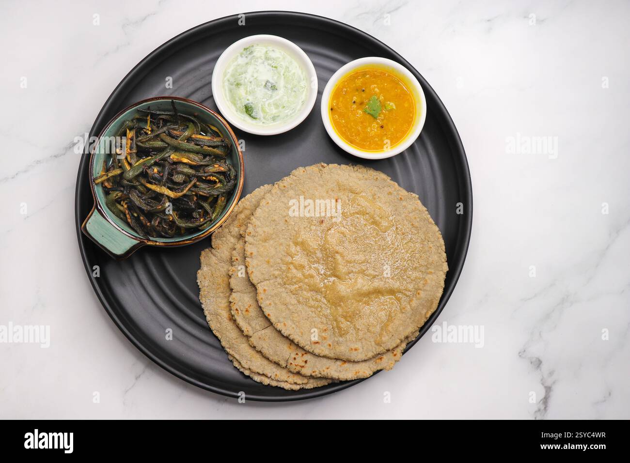 Roti and Sabzi. Indian vegetarian Thali includes bhindi fry, yellow ...