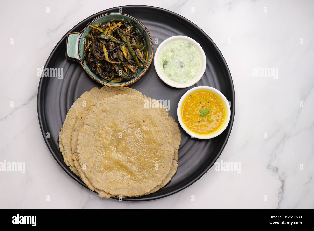 Roti and Sabzi. Indian vegetarian Thali includes bhindi fry, yellow ...