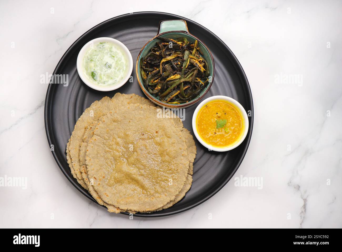 Roti and Sabzi. Indian vegetarian Thali includes bhindi fry, yellow ...