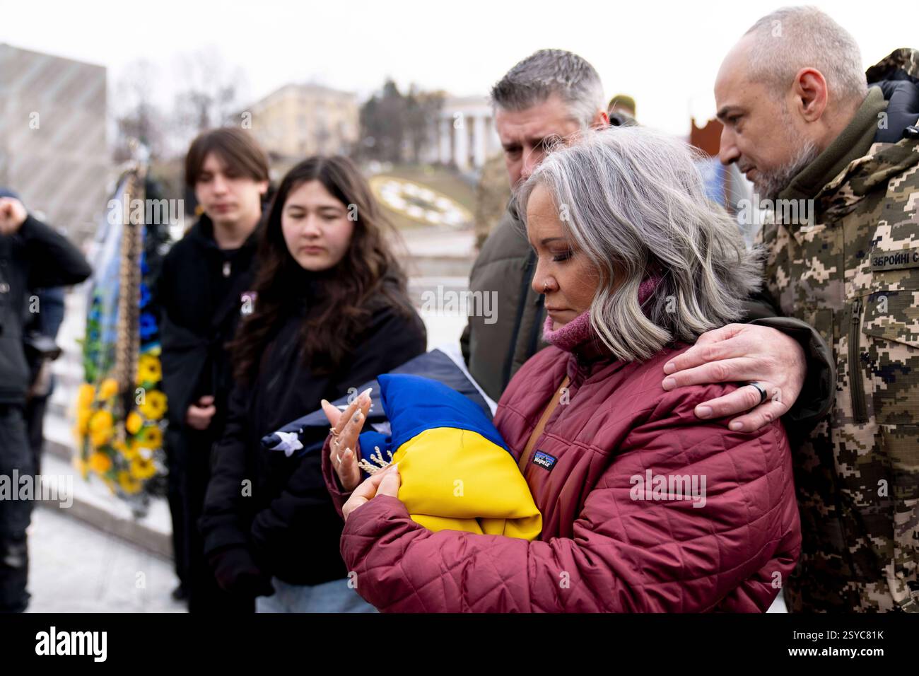 Mother Leslie Hertweck holding Ukrainian flag in hand at memorial ...