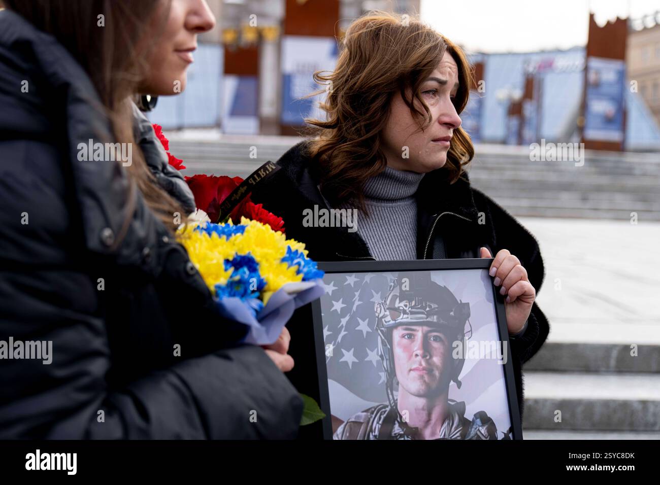 Woman with tears on her face holding portrait of the fallen soldier at ...