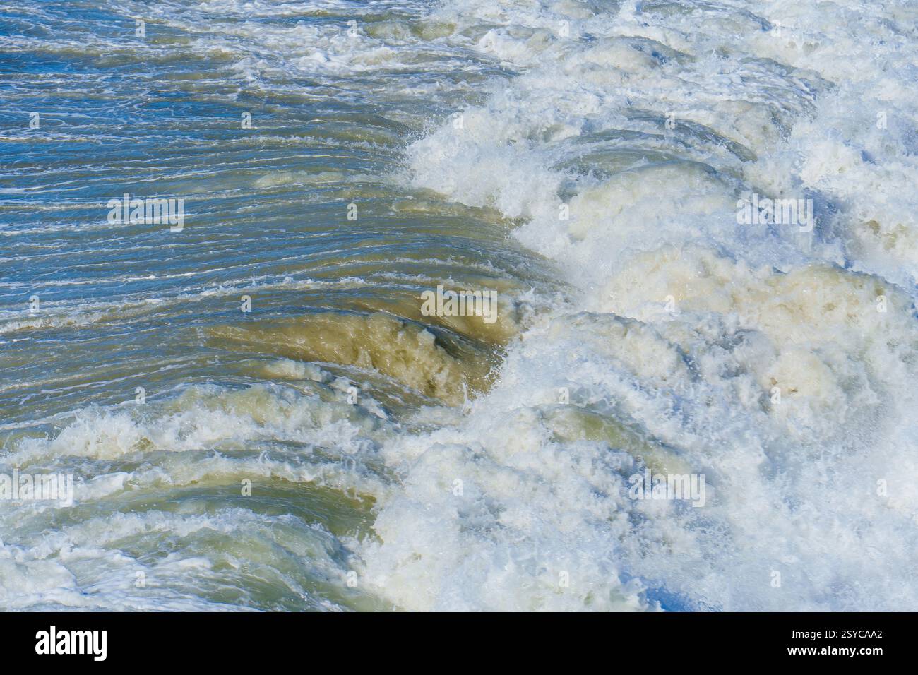 Powerful waves with foamy crests rolling towards the shoreline ...
