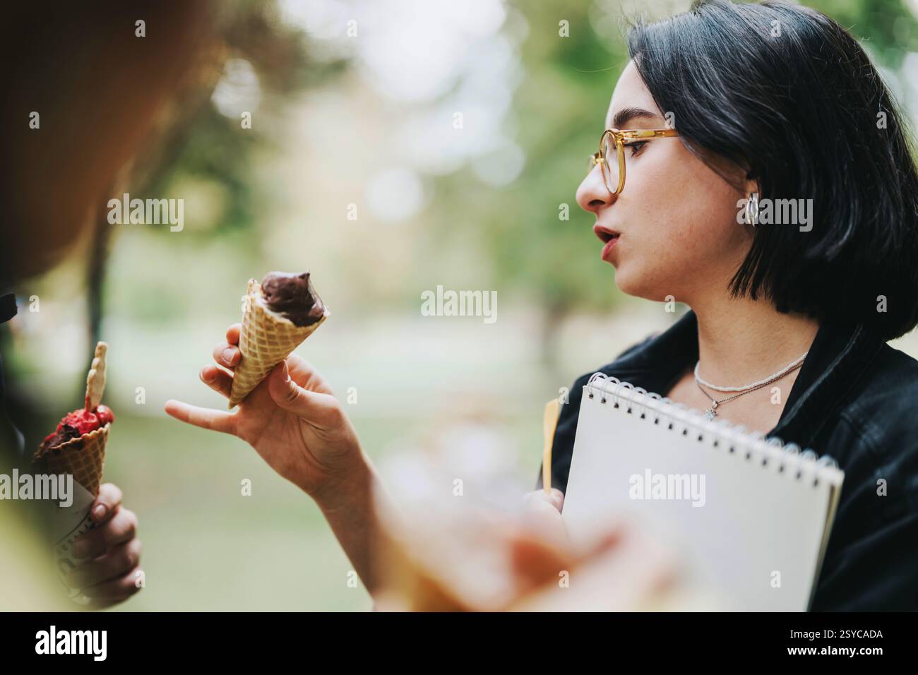 Students enjoying ice cream with professor after classes outdoors Stock ...