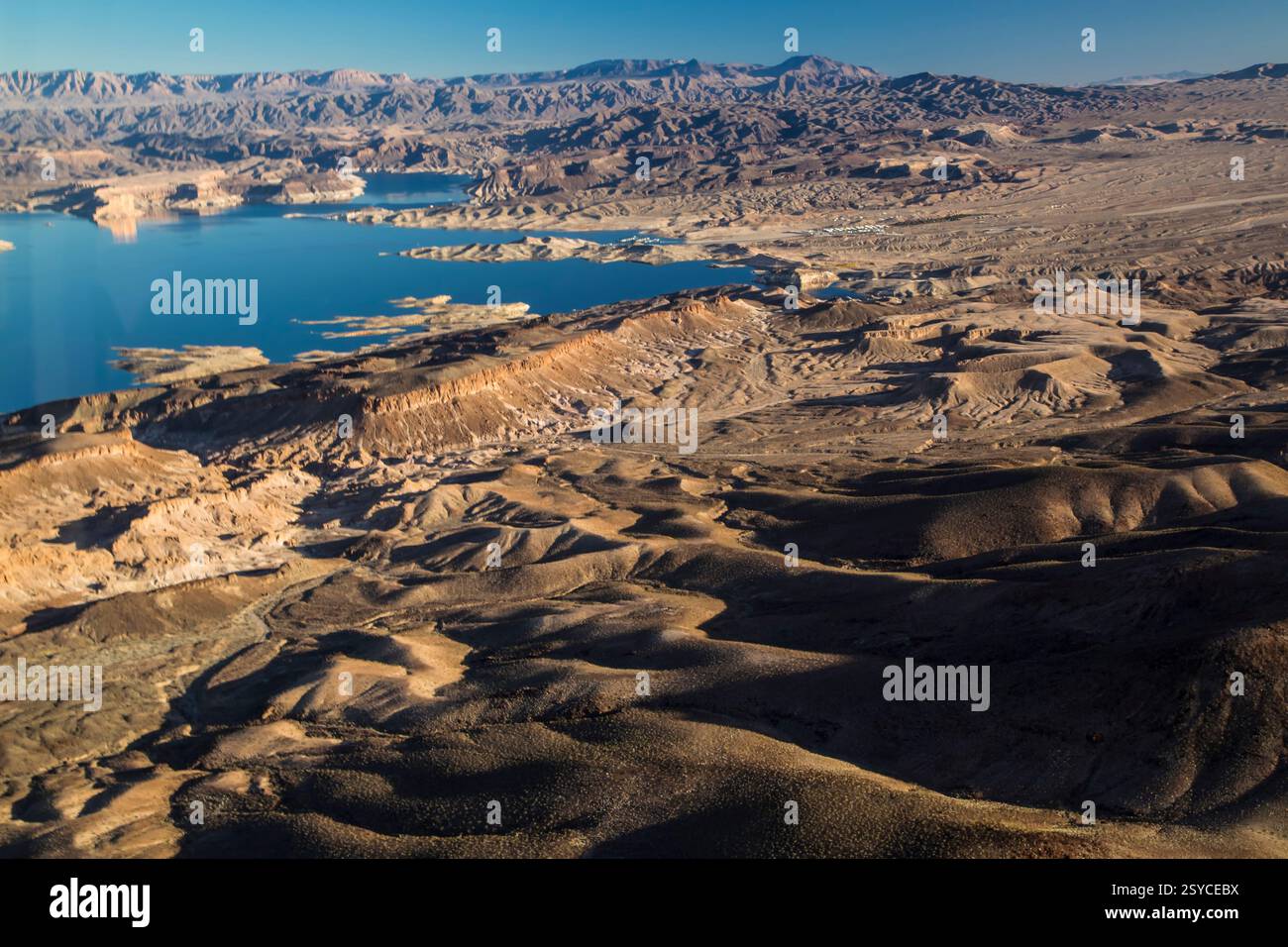Desert landscape with a body of water in the background. The water is a ...