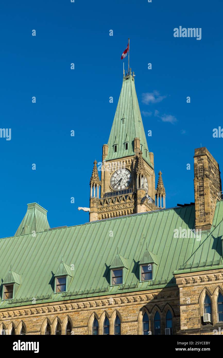 Tall clock tower with a green roof and a red and white flag on top. The ...