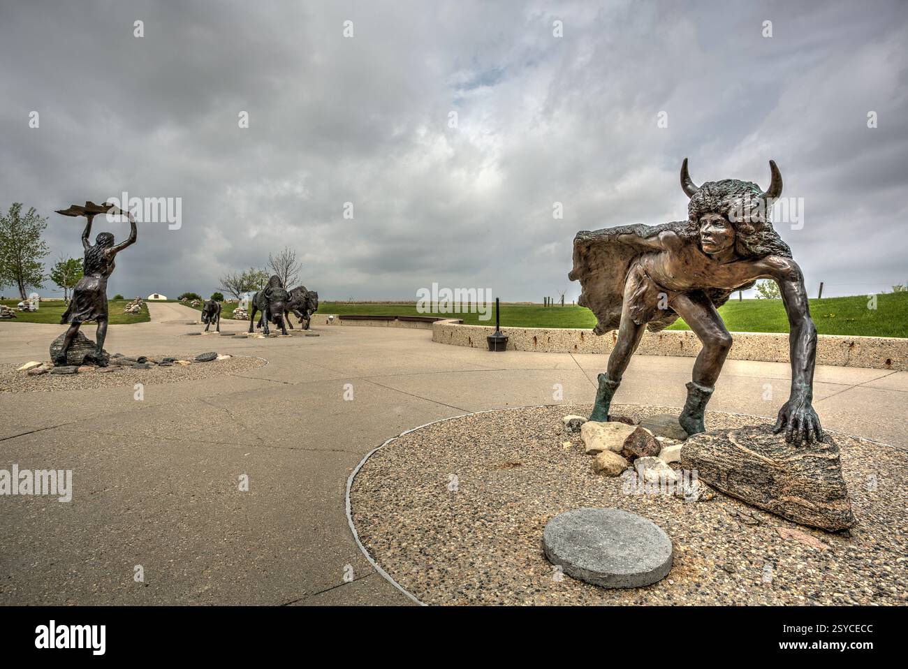 Statue of a man with horns is on a rock. There are other statues of ...