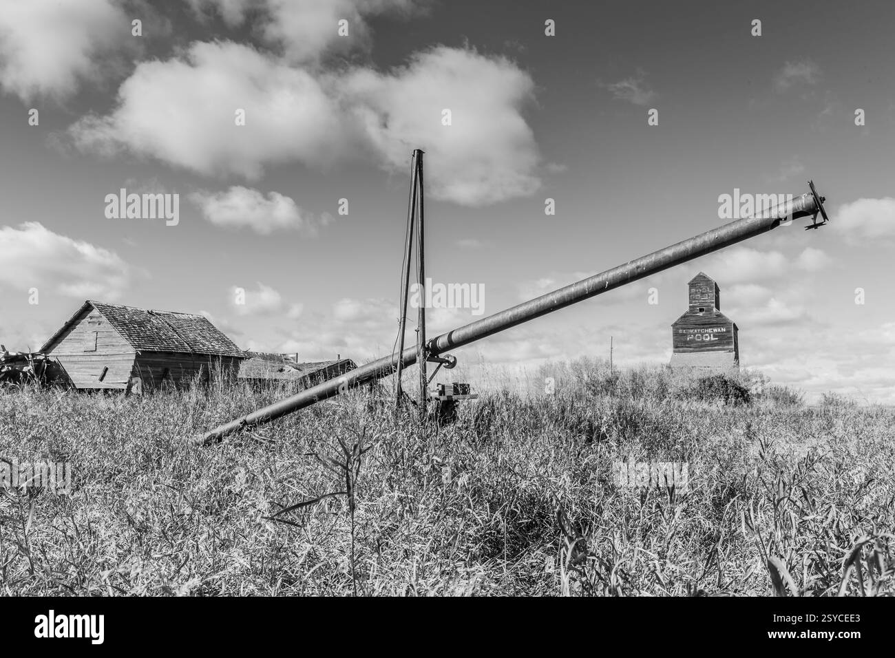 Pole is leaning against a building. The pole is in a field. The pole is ...
