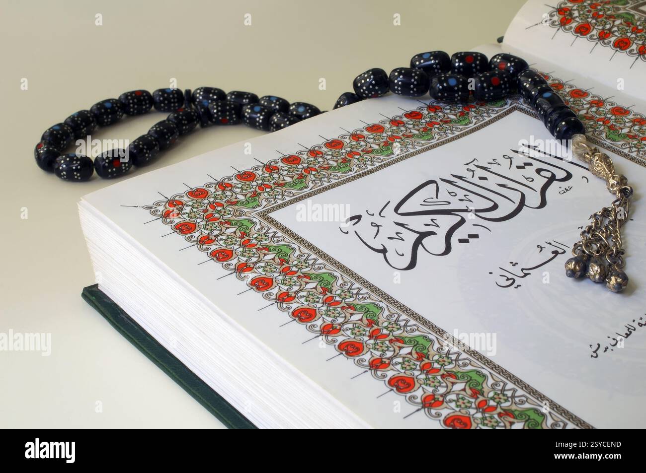 An open copy of the sacred text of Islam Quran also romanized Qur'an or ...