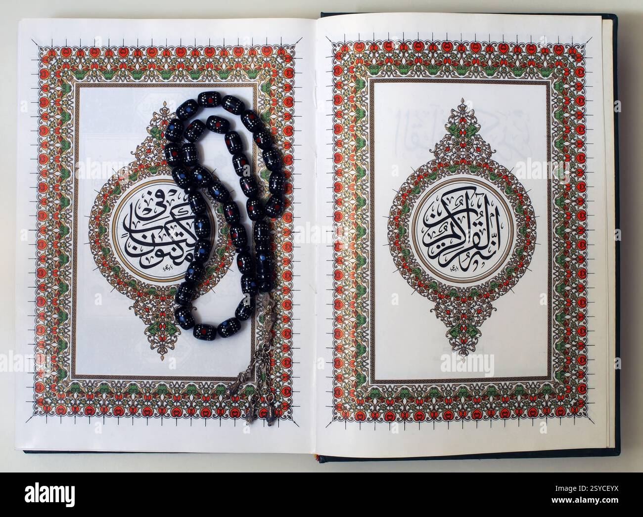 An open copy of the sacred text of Islam Quran also romanized Qur'an or ...