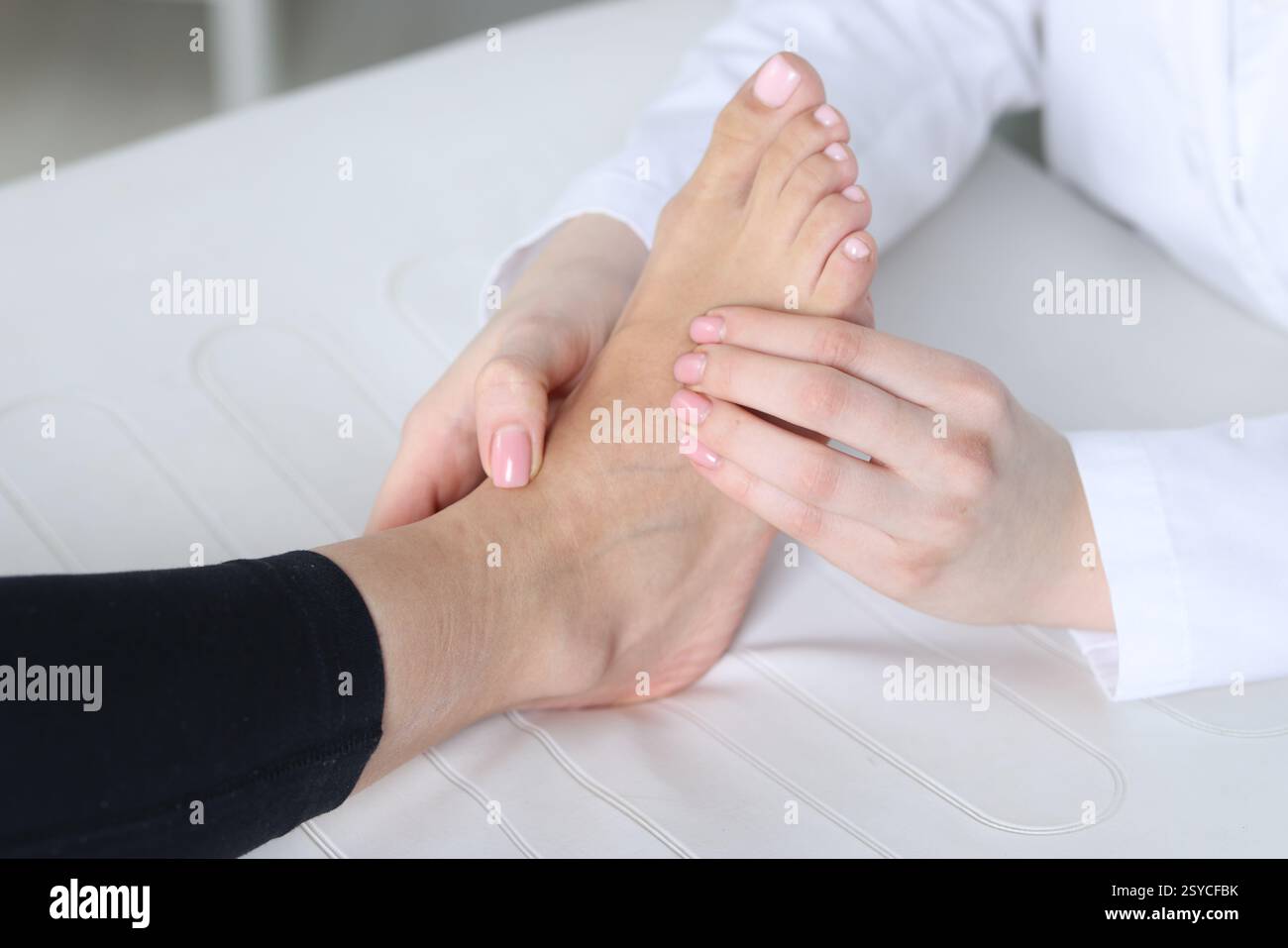 Female orthopedist examining foot patient hi-res stock photography and ...