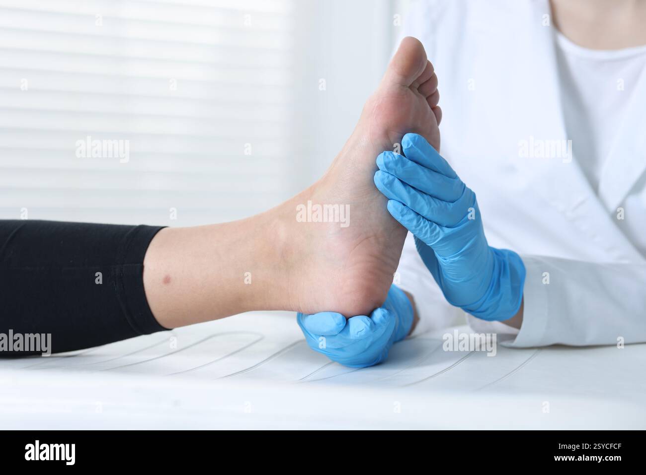 Female orthopedist examining foot patient hi-res stock photography and ...