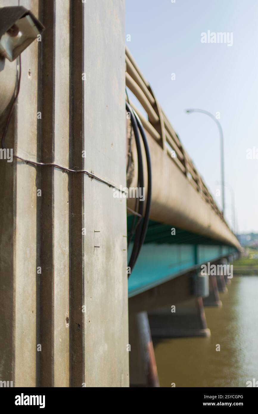 Bridge with a blue railing. The railing is attached to a metal pole ...