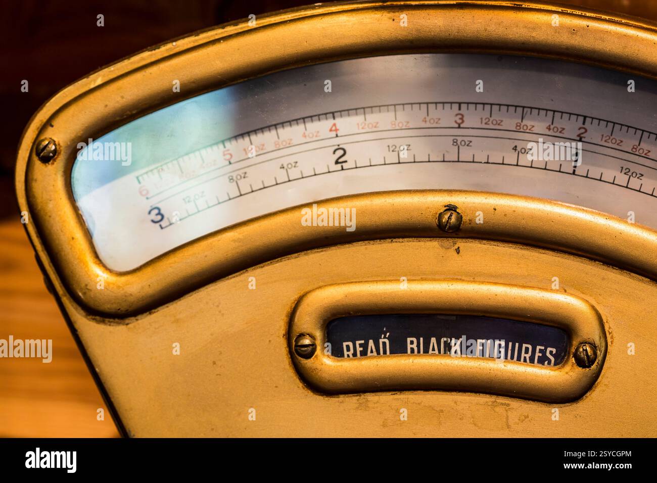 Vintage scale with a black figure on it. The scale is made of gold and ...