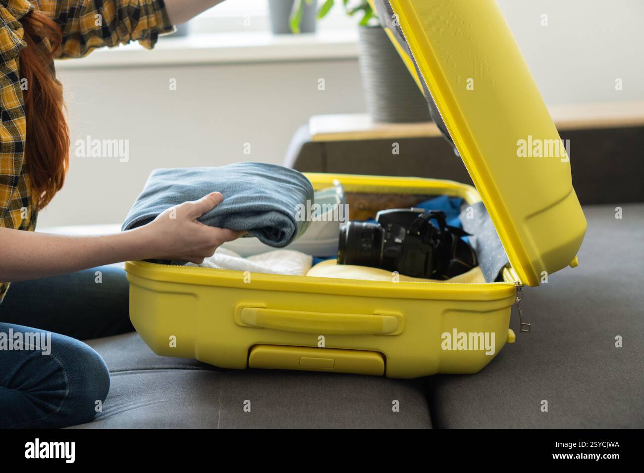 Packing Essentials for a Journey A woman in a yellow plaid shirt ...