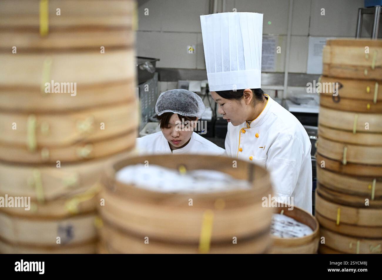 (250228) -- BEIJING, Feb. 28, 2025 (Xinhua) -- Wu Huaxia (R) instructs ...