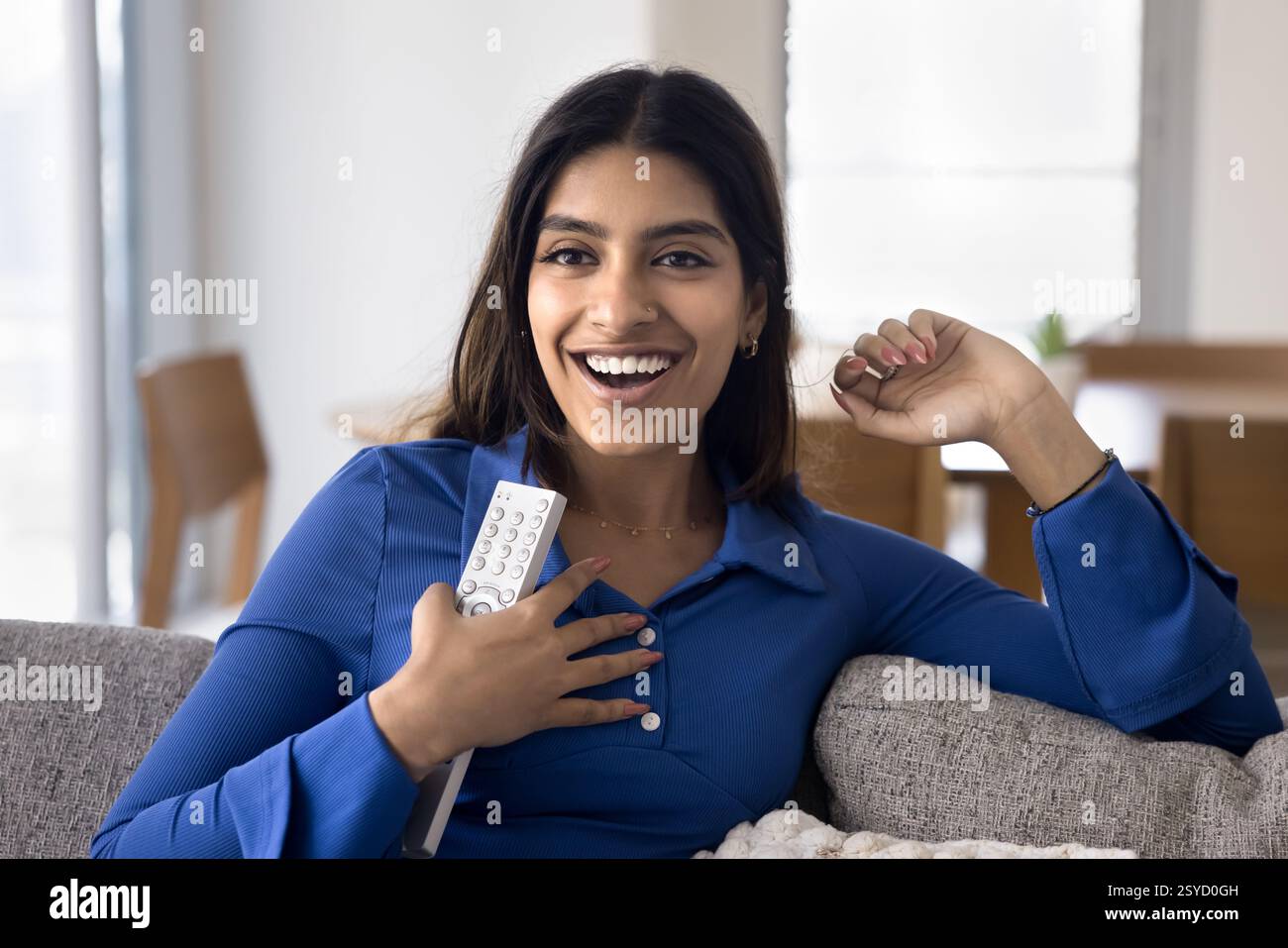 Woman feels thrilled and pleasantly surprised while watching TV show ...
