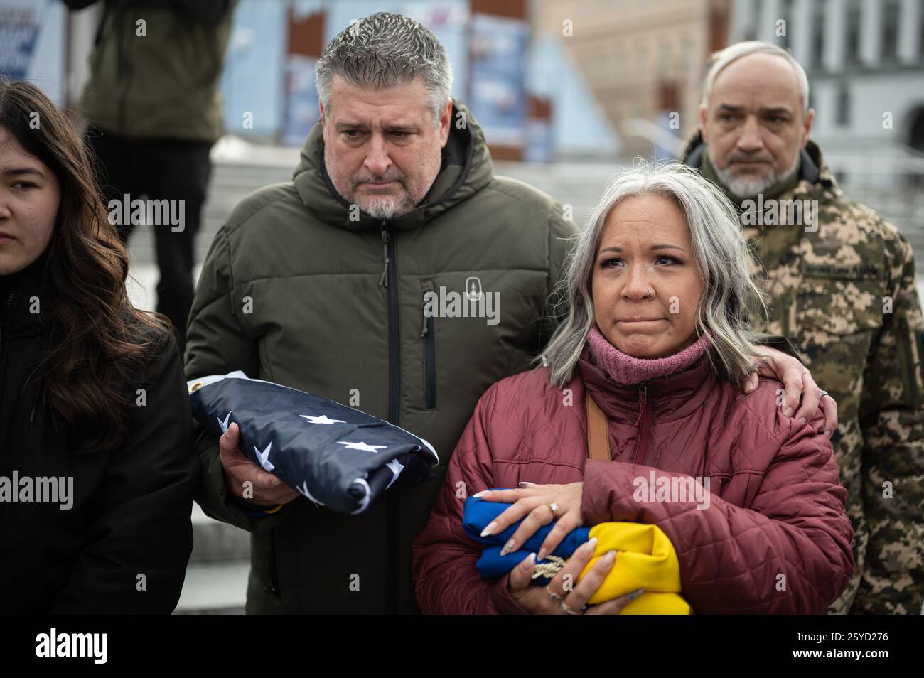 Parents Leslie and John Hertweck hold the flags of Ukraine and the ...