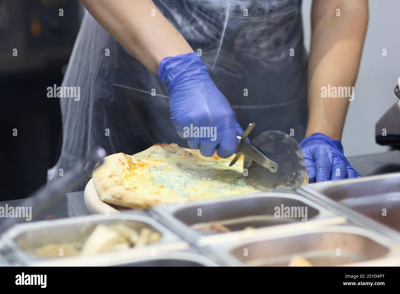 Chef cuts pizza in a pizzeria. Food Stock Photo - Alamy