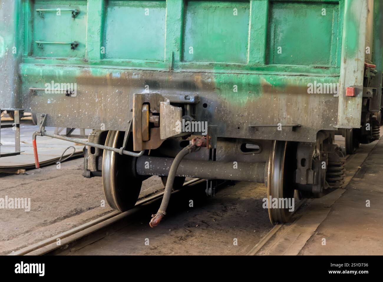 Green train wagon is under restoration on tracks inside railway ...