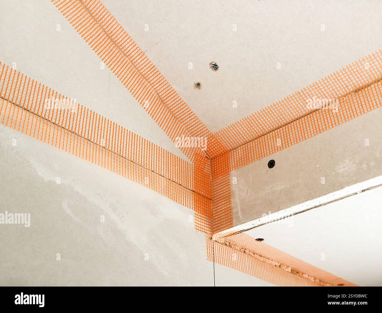 Tape on the joints of plasterboards on the walls and ceiling of a house ...