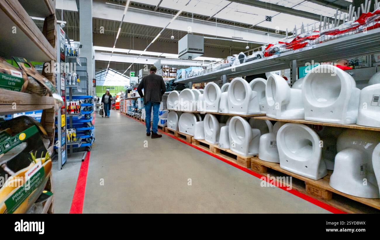 22 February 2025, Hamburg: Customers walk through a DIY store. Photo ...