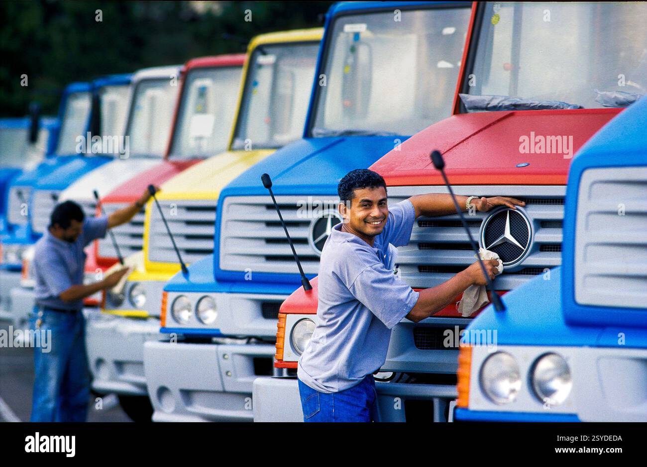Brazil, Sao Paulo. Mercedes workers clean the newly produced trucks ...