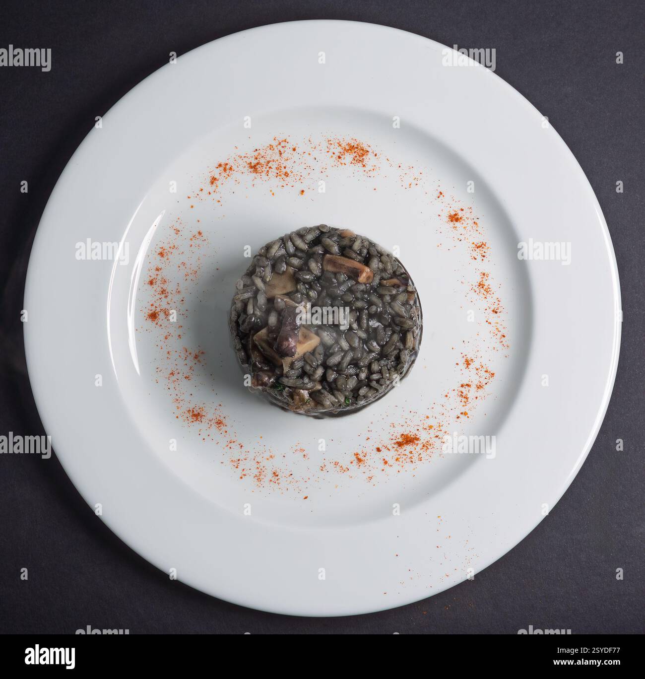 Italian squid ink risotto served in a white dish Stock Photo - Alamy