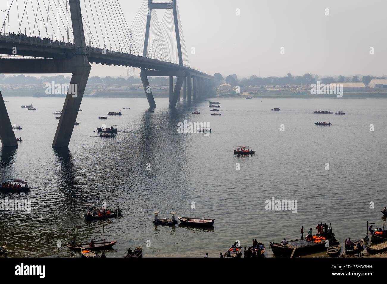 pilgrims on boat crossing artistic road bridge over sacred ganges river ...