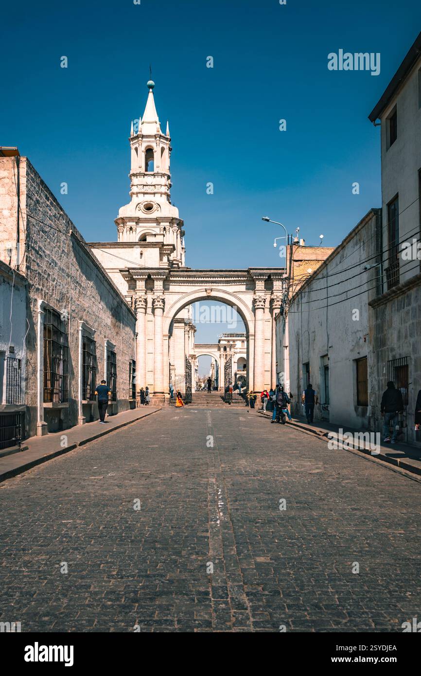 A charming colonial street with a historic arch framing the Basilica ...