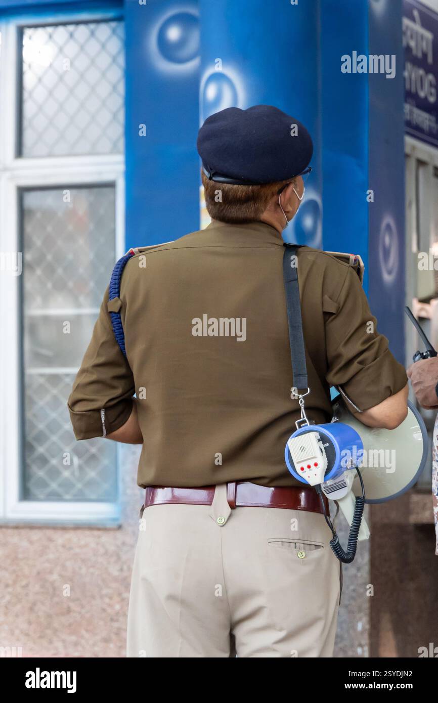 police man with loudhailer controlling crowd of mass gathering at ...