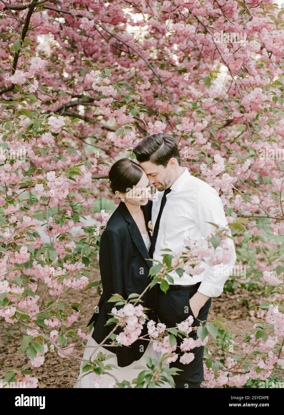 A couple in formal attire shares an intimate moment surrounded by ...