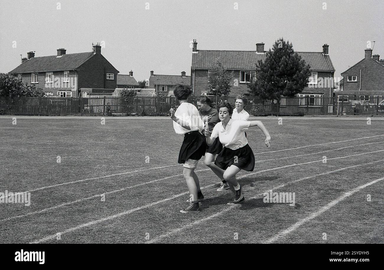 1989, school sports day, schoolgirls in PE kit competing in a relay ...