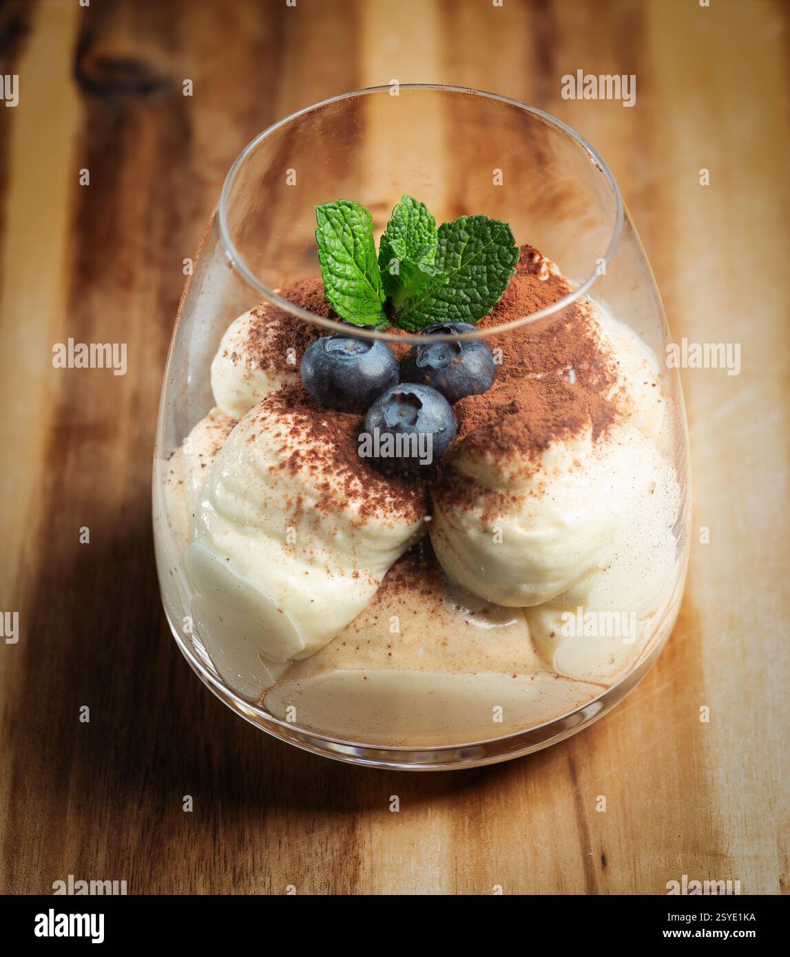 Classic italian tiramisu dessert served in a glass with fresh mint and ...