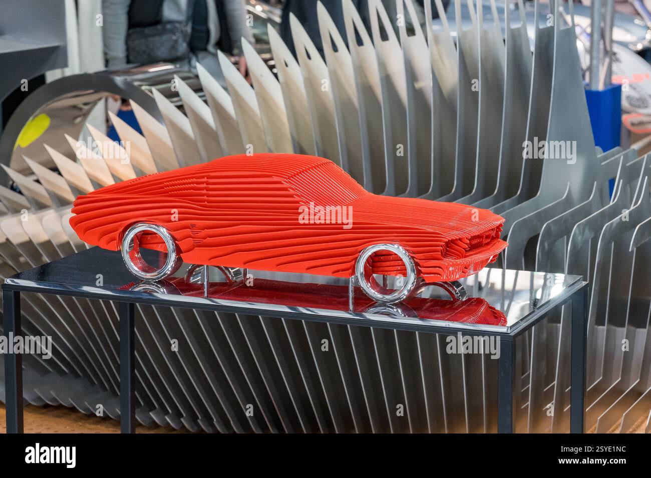 Vibrant red car model stands out amongst sleek metallic designs at an ...
