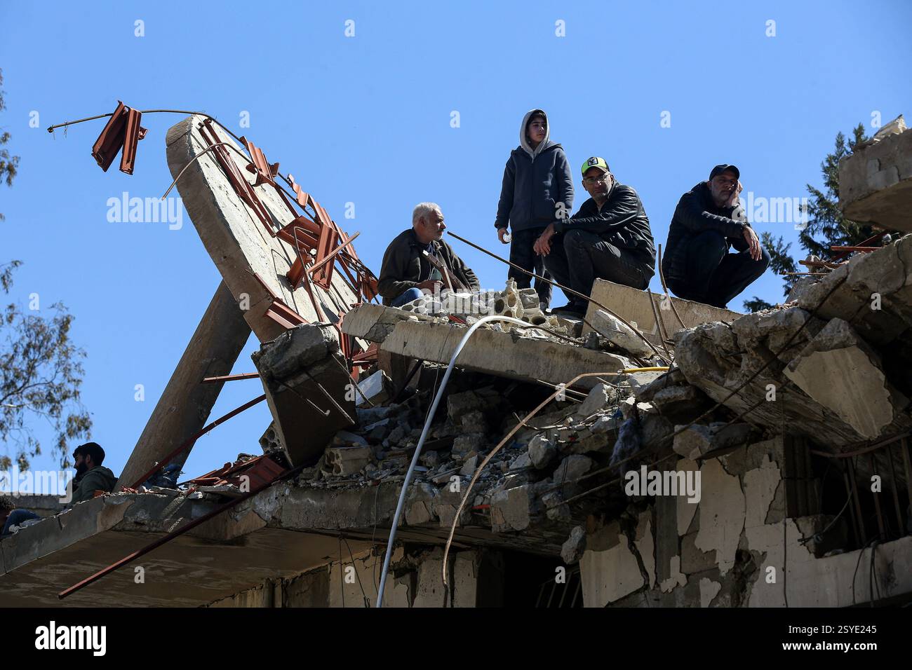 Aitaroun, Lebanon. 28th Feb, 2025. Mourners sit on the wreckage of a ...