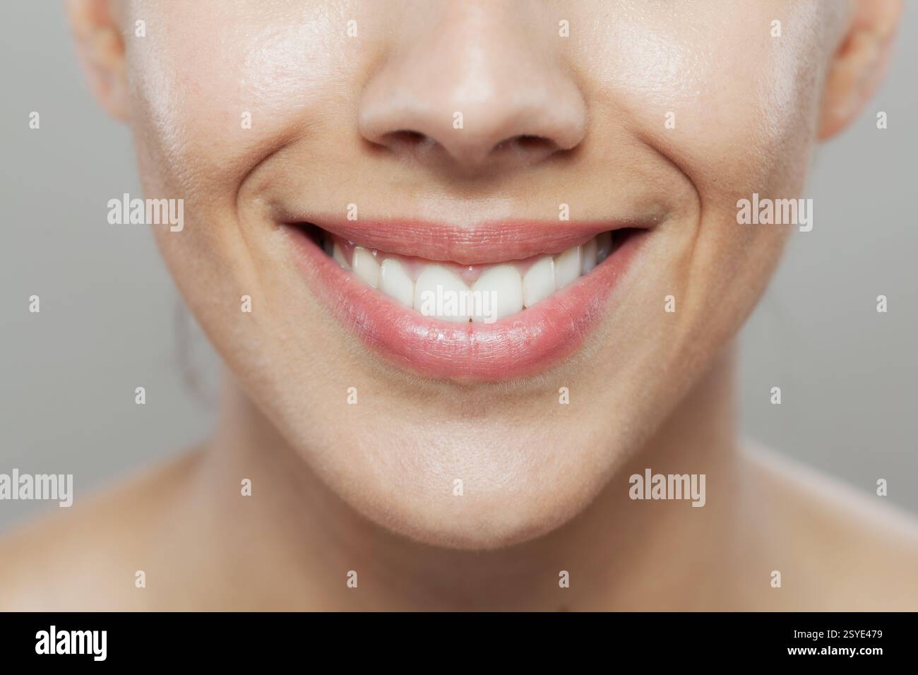 This image captures the lower face of a woman smiling, highlighting her ...