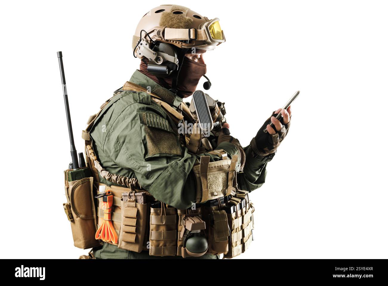 A military personnel in full tactical gear, using a smartphone as part ...