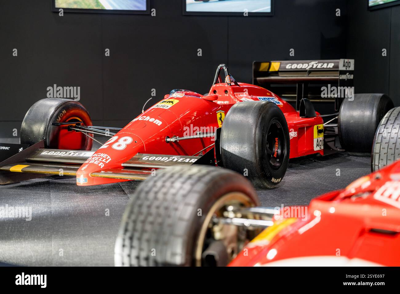A classic red Formula One car at a city exhibition embodies innovative ...